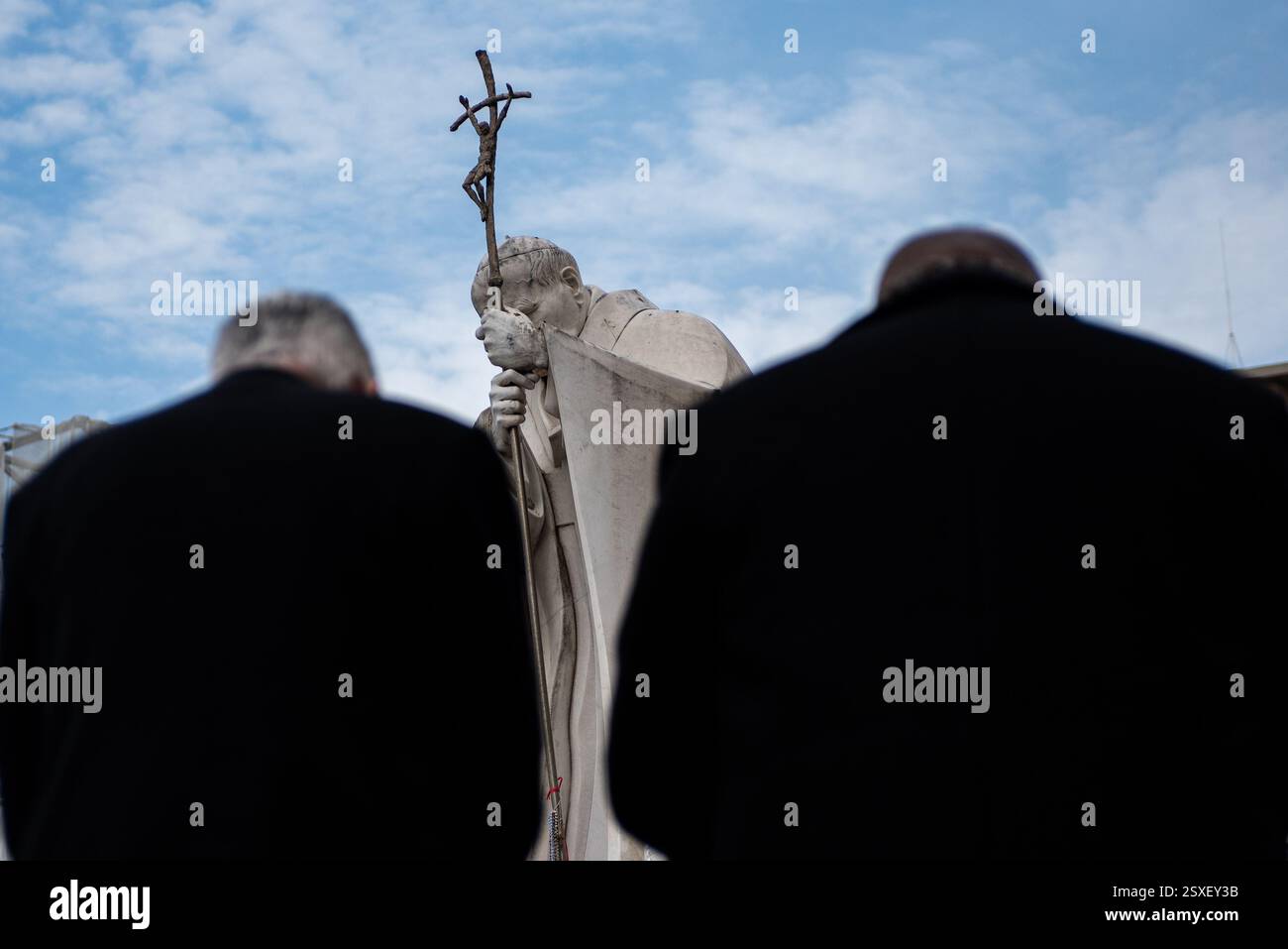 Rome, Italy. 24th Feb, 2025. Two priests pray in front of the statue of ...