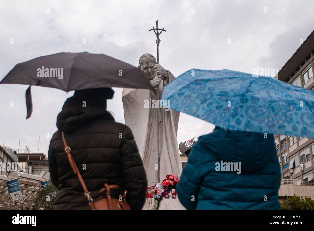 Rome, Italy. 24th Feb, 2025. Faithful pray in front of the statue of ...