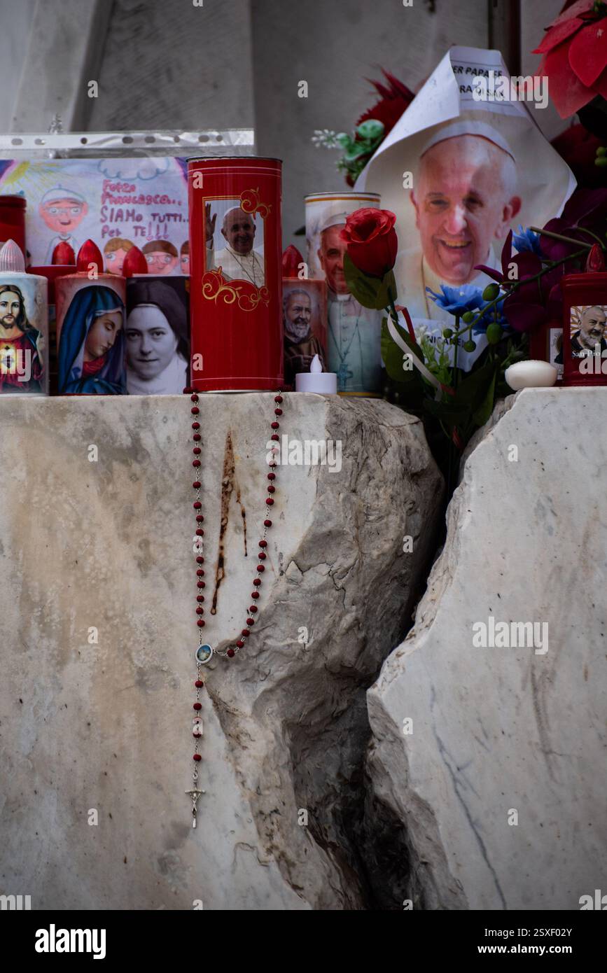 Tributes of flowers, images, candles, and drawings under the statue of ...