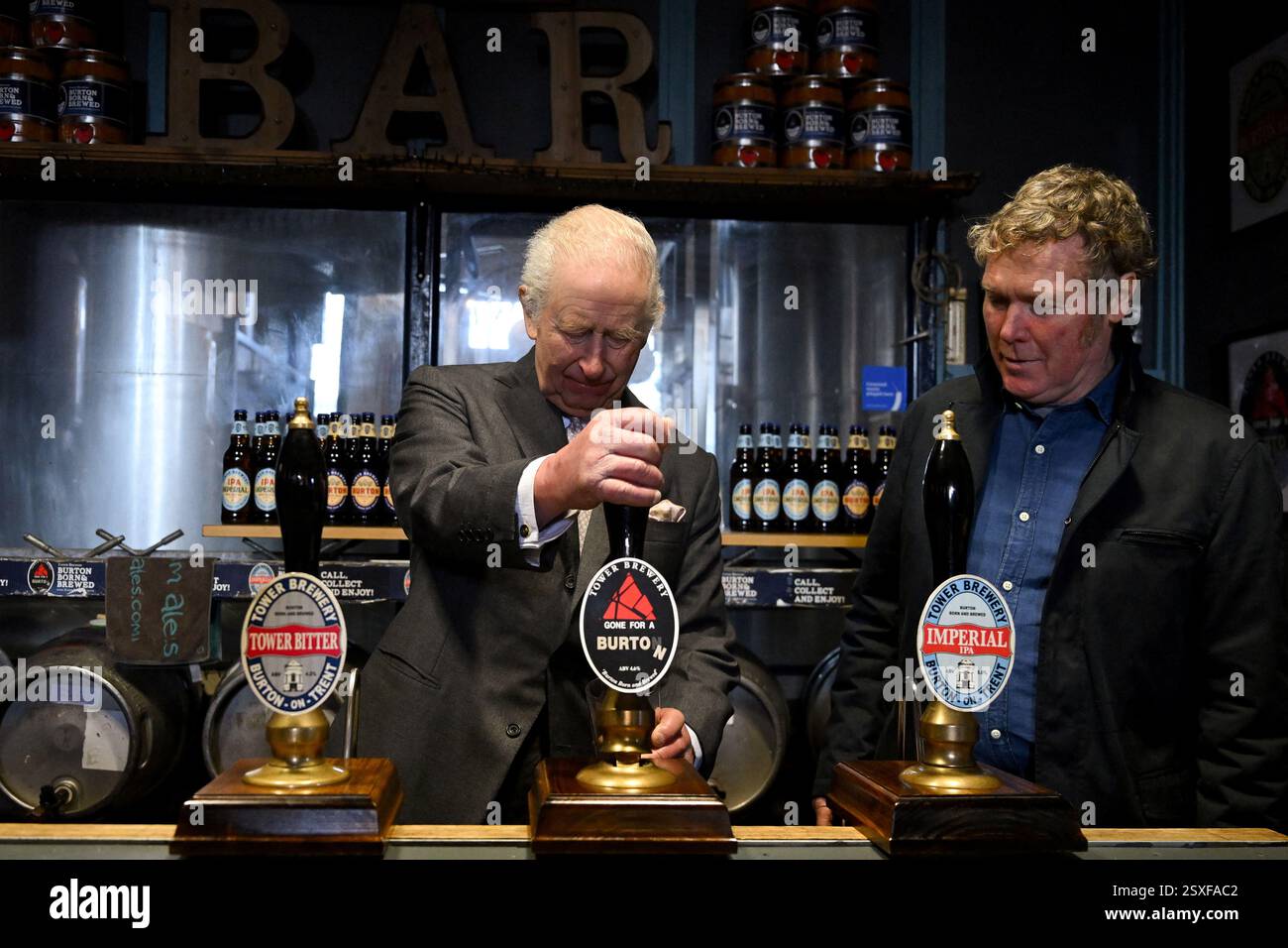 King Charles III pulls a pint alongside Tower Brewery owner John Mills, during a visit to Tower ...