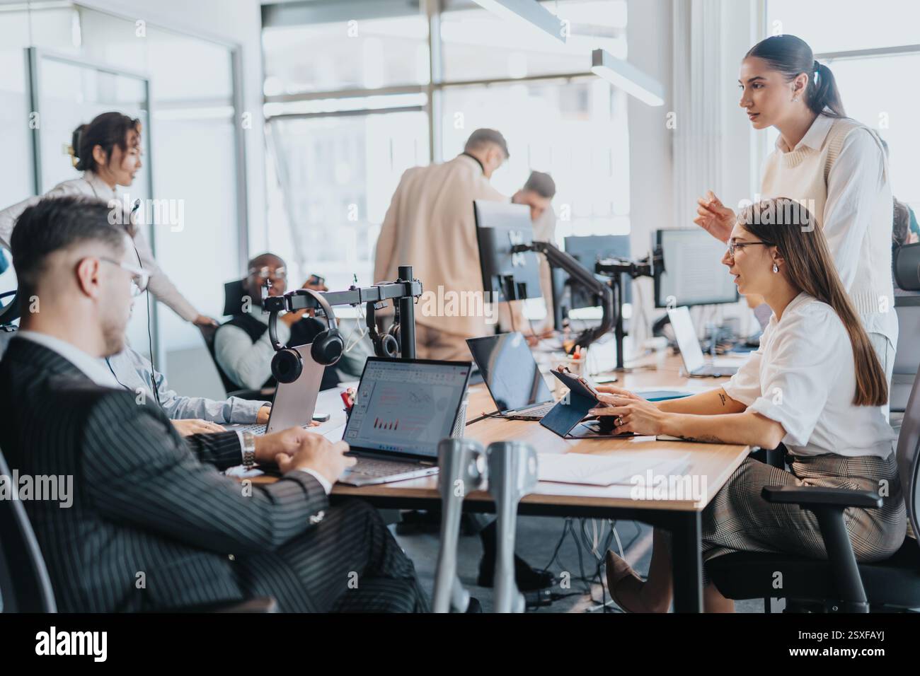 Diverse business team collaborating in modern office setting. The image showcases teamwork ...