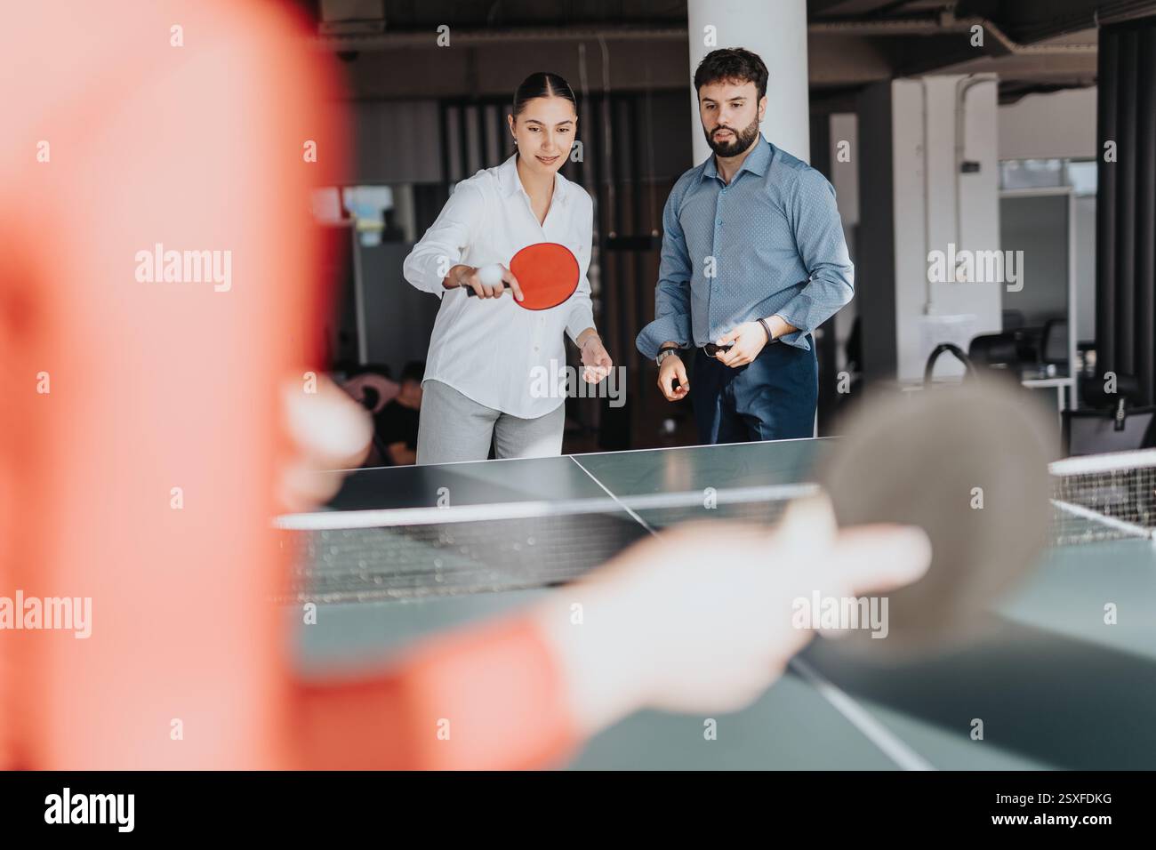 Business colleagues enjoy a friendly game of table tennis Stock Photo ...