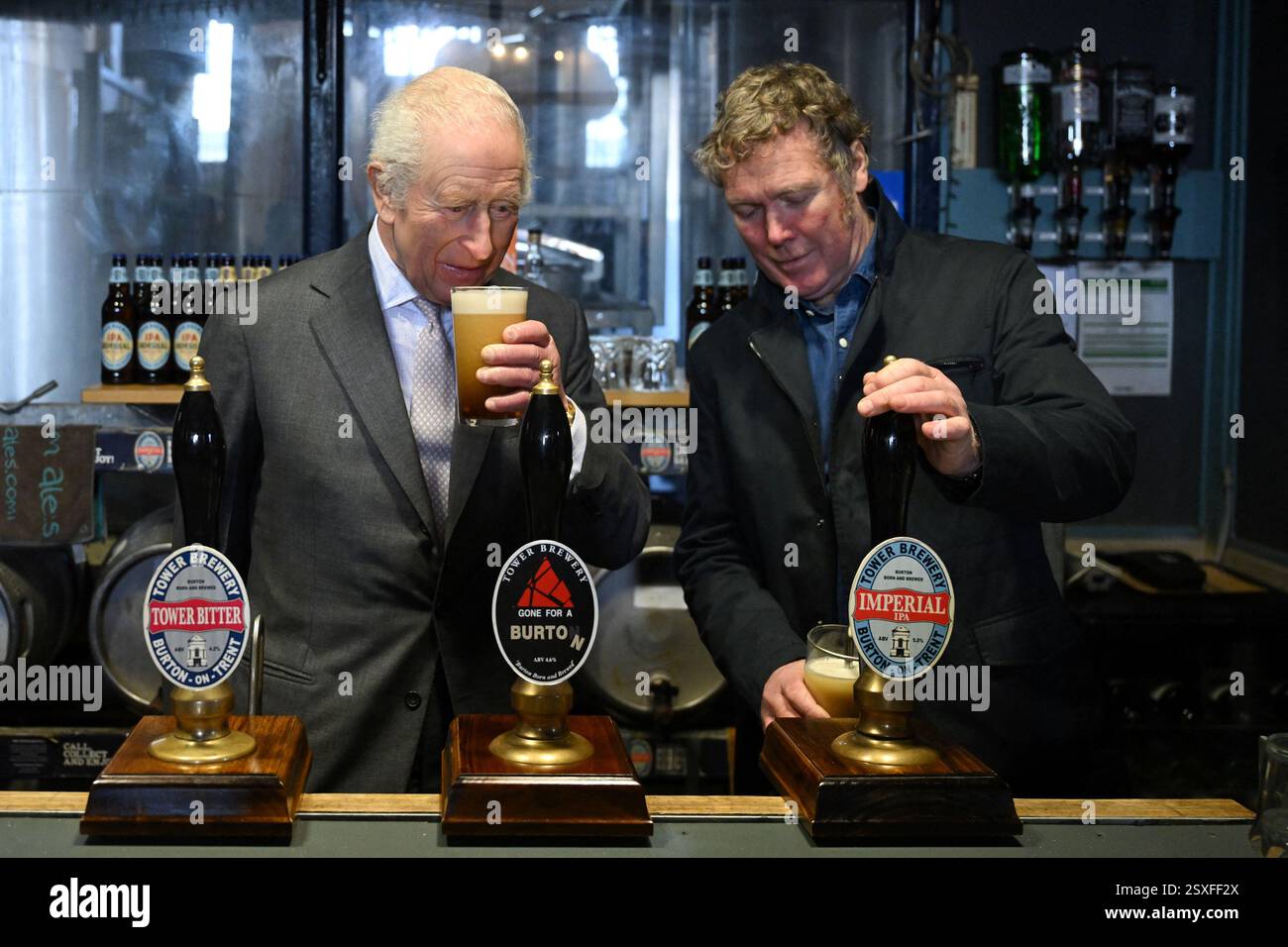King Charles III pulls a pint alongside Tower Brewery owner John Mills, during a visit to Tower ...