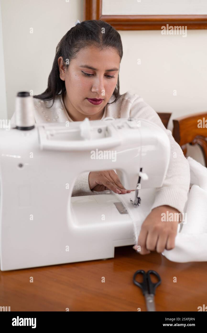 A young woman sewing on a sewing machine at home, perfect for content ...