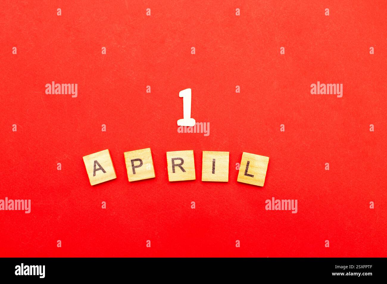 the inscription 1 first April made by wooden cubes on red background ...
