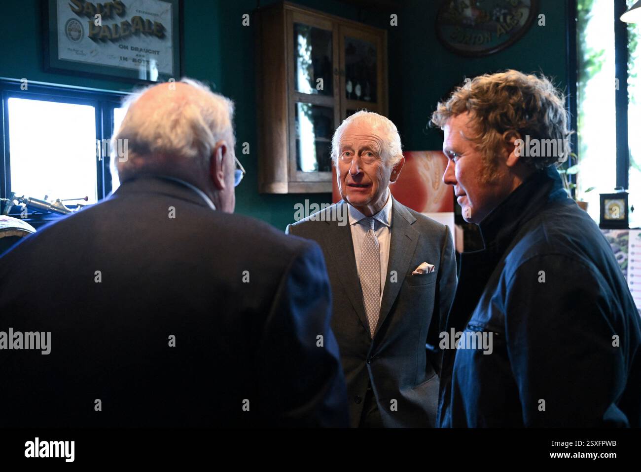 King Charles III talks with Tower Brewery owner John Mills and Harry White, Chairman of the ...