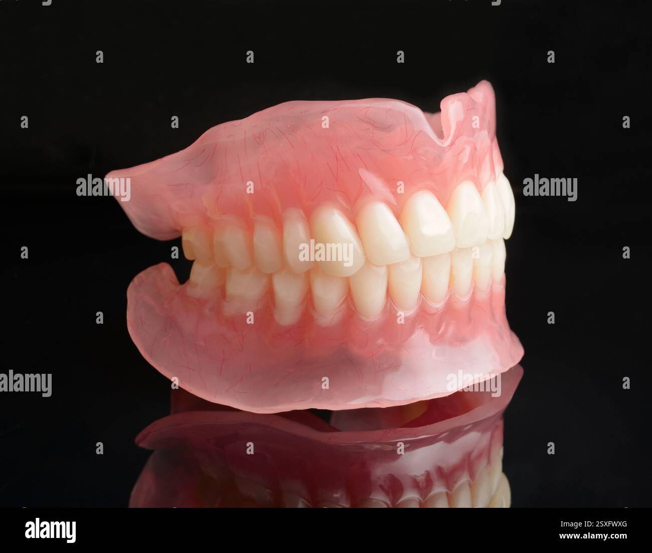 Modern full denture dentures with reflection on black Stock Photo - Alamy