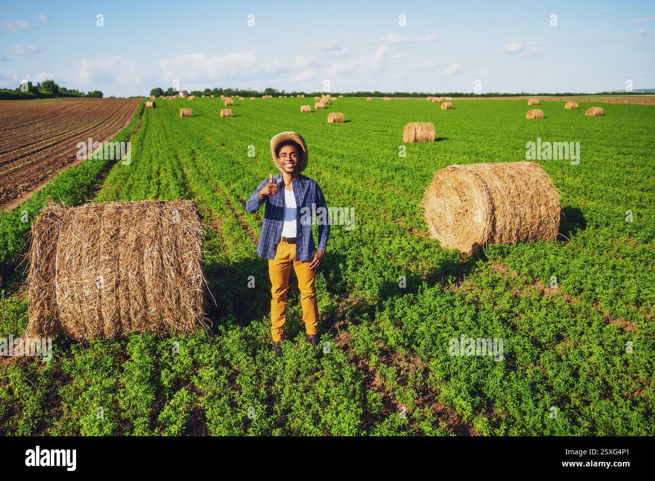 African farmer is standing in his agricultural field. He is cultivating ...