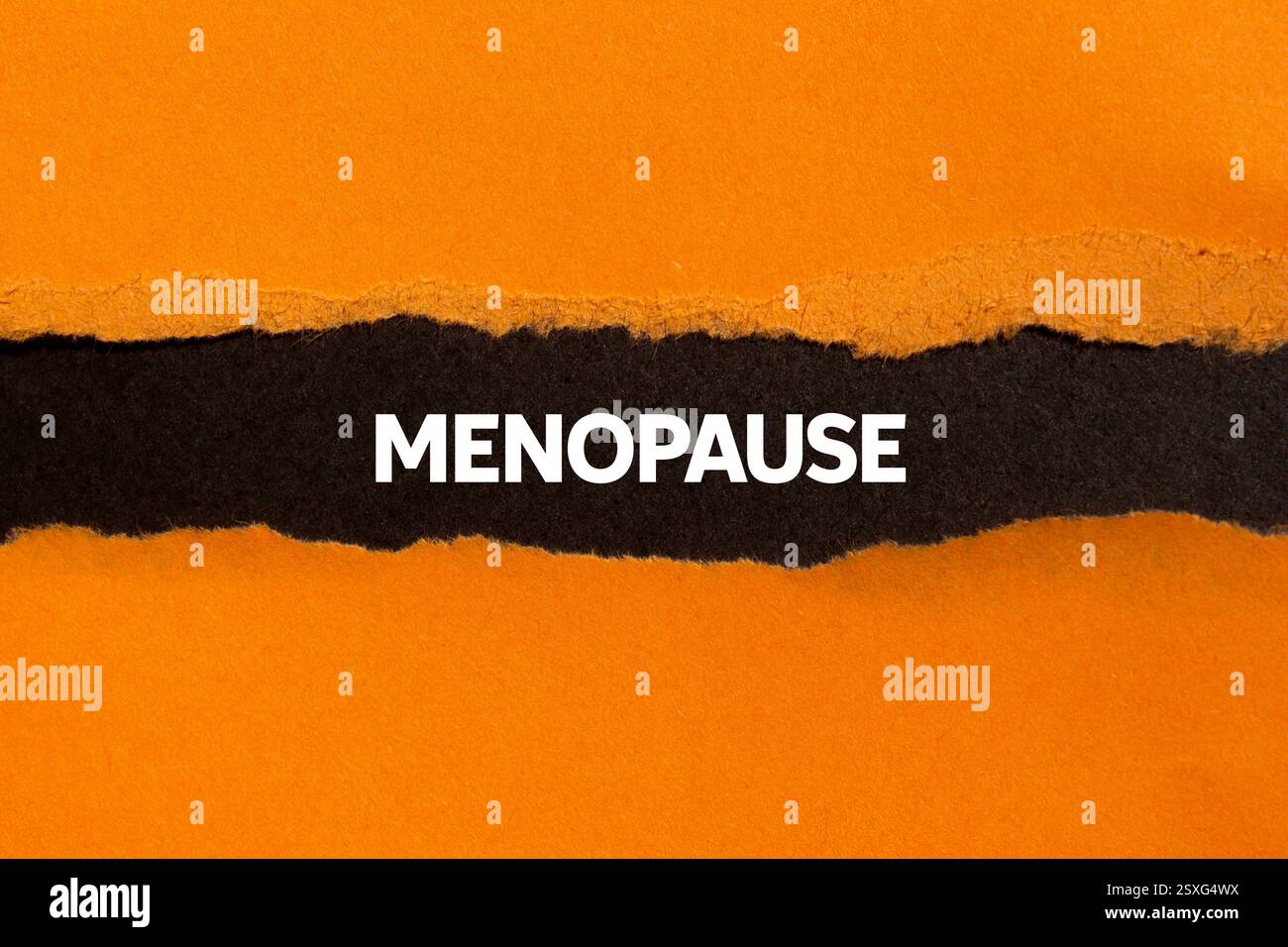 Menopause message written on ripped torn orange paper on black ...