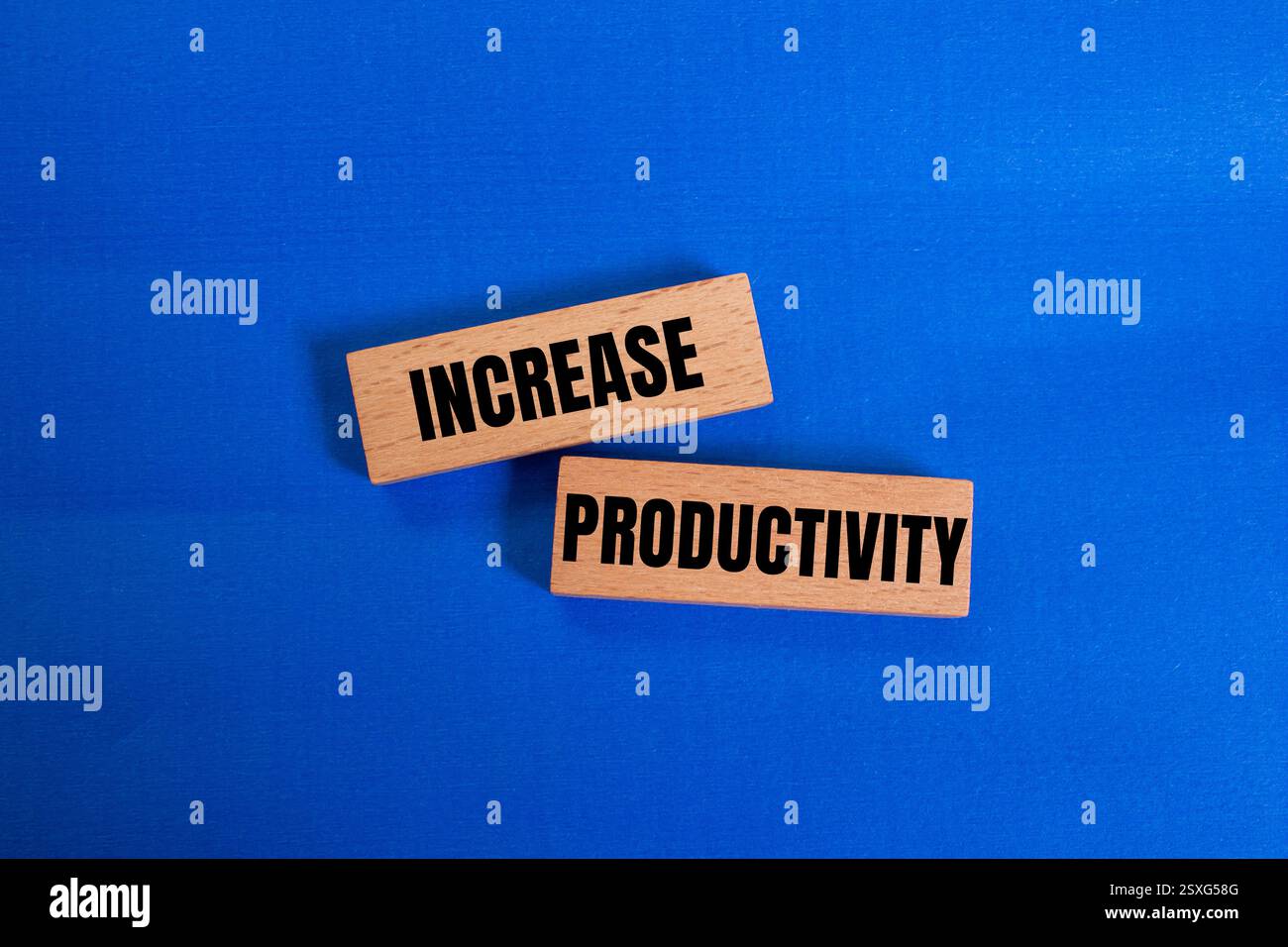 Increase productivity message written on wooden blocks on blue background. Conceptual increase ...