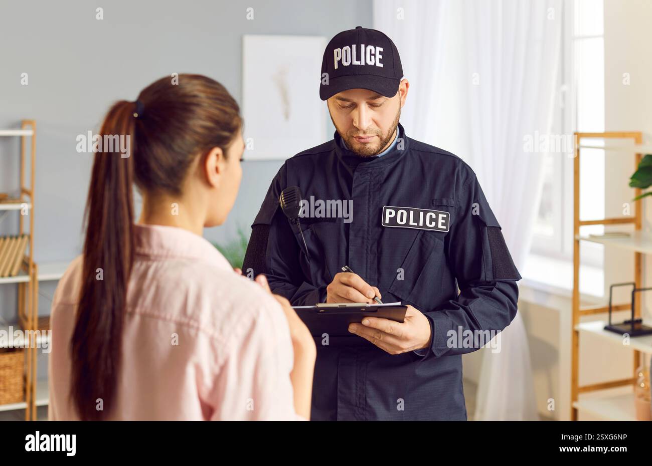 Policeman making victim interview after burglary talking with a young ...