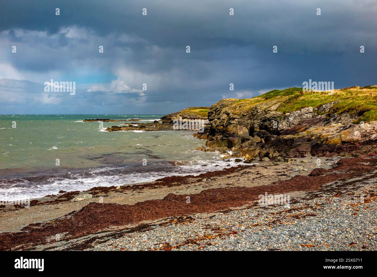 Stormy sky over the shingle beach at Cemlyn Bay an SSSI on the north ...