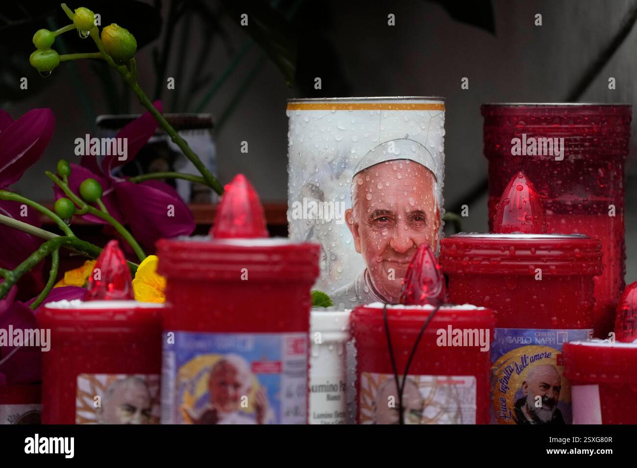 Raindrops are are seen on candles adorned with a picture of Pope ...