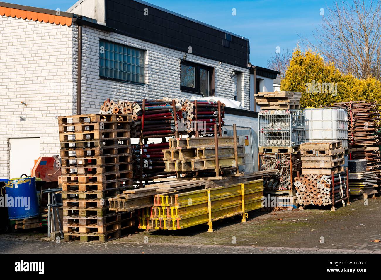A storage area features stacks of wooden pallets and construction ...