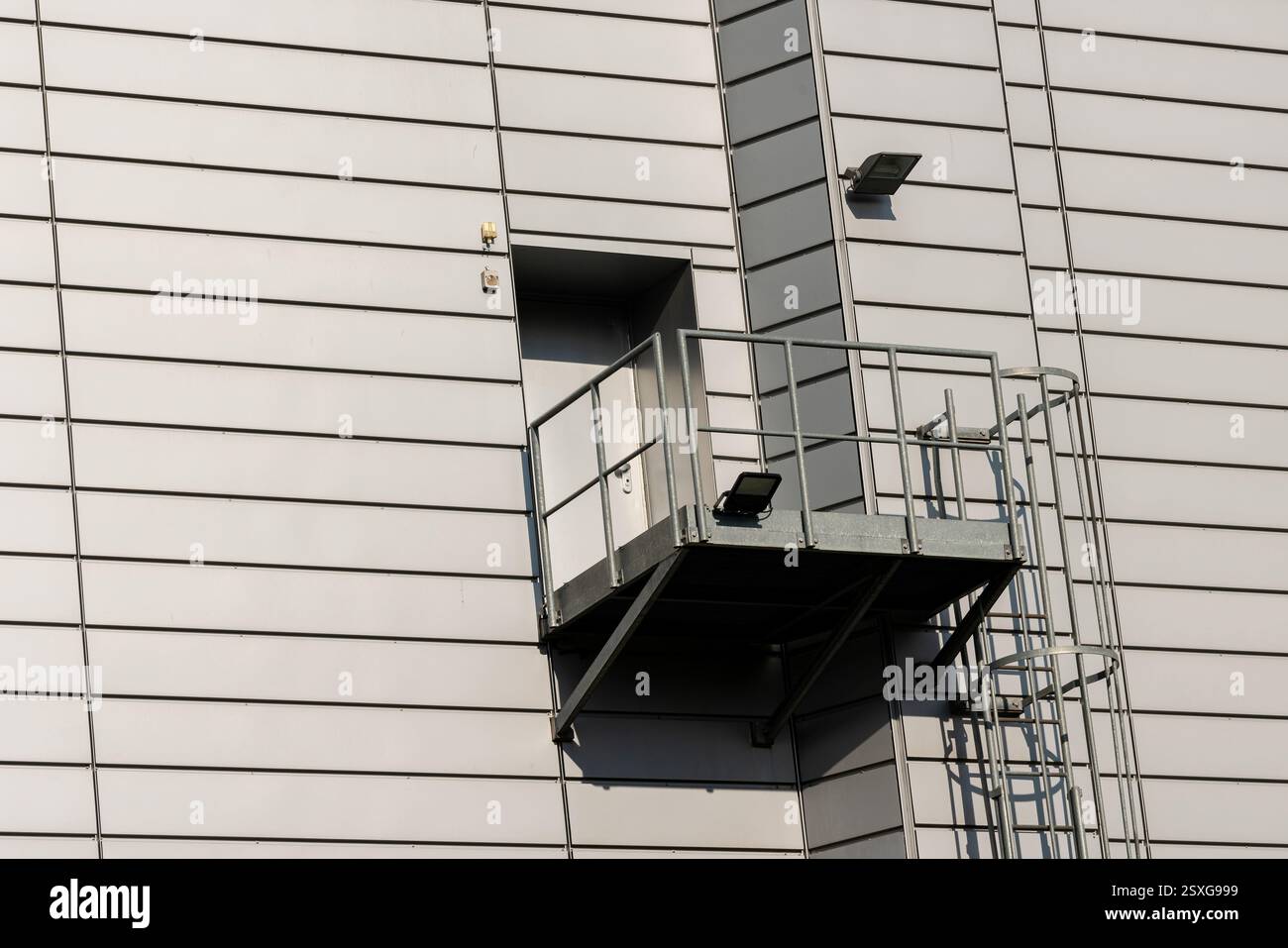A modern building features an exterior balcony with a safety railing ...