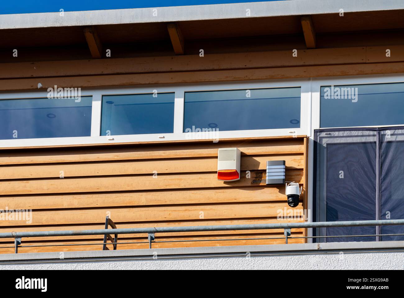 A security system is mounted on the exterior of a contemporary wooden ...