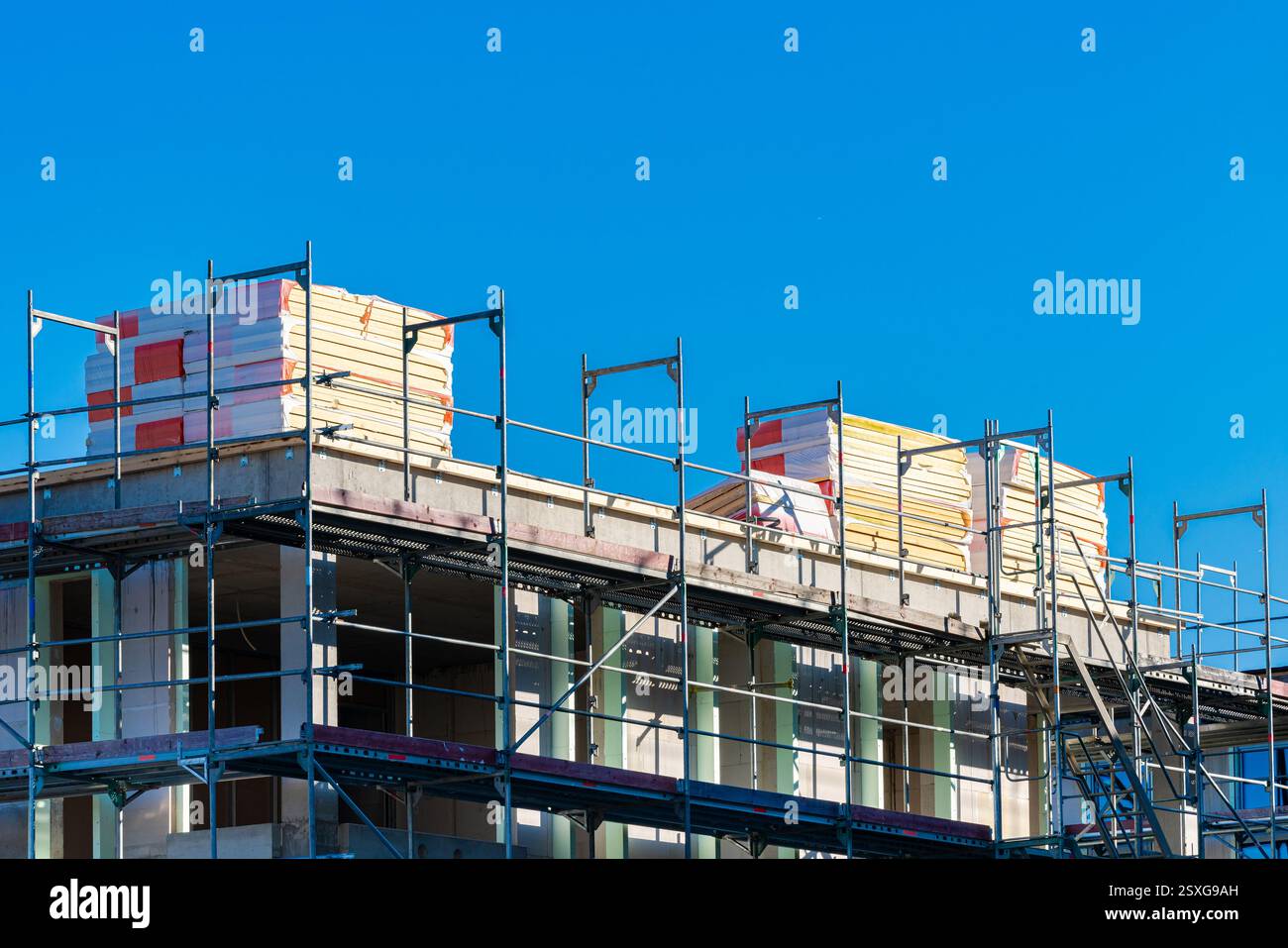 A building under construction surrounded by scaffolding. Building ...