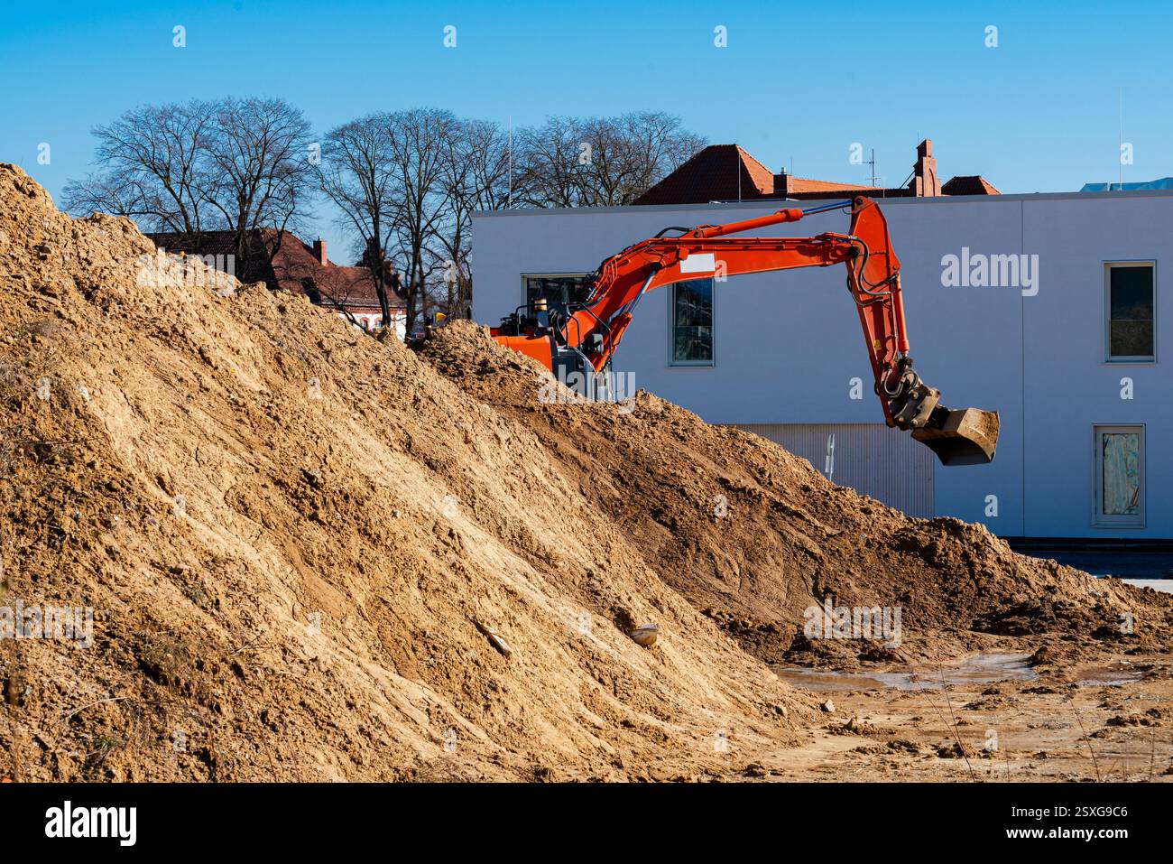 A heavy machinery excavator is actively digging at a construction site ...