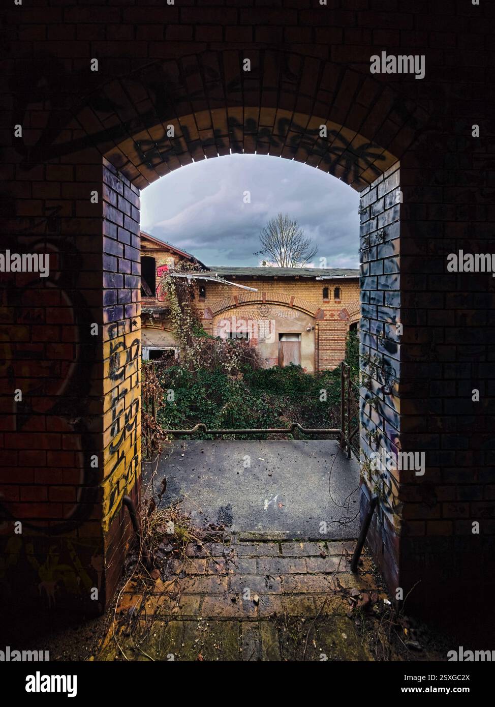 Arched brick passage to a small balcony opening to an overgrown ...