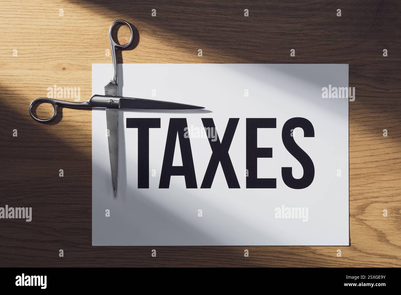 TAXES text on a sheet and scissors: tax cut and tax reduction concept ...