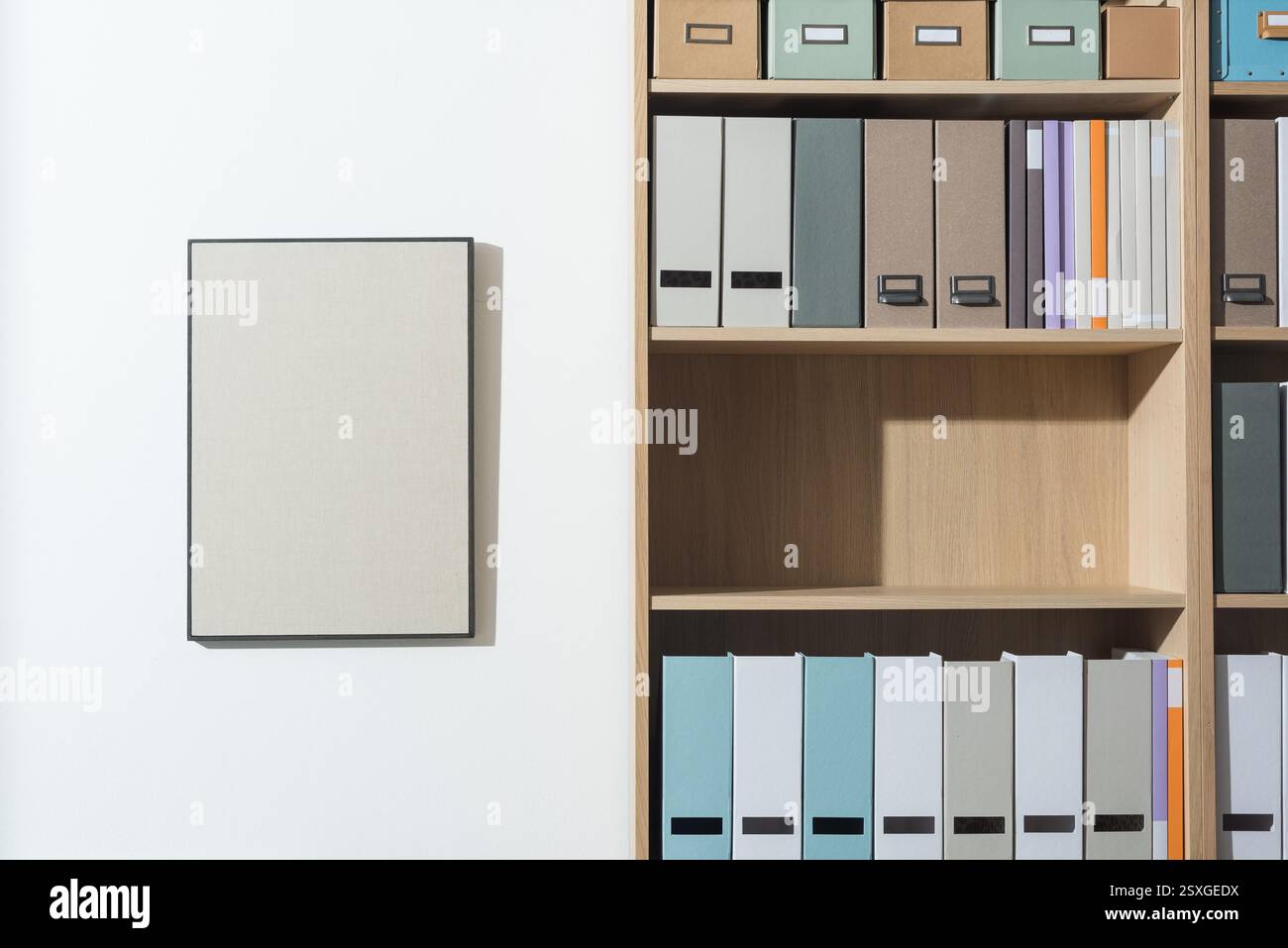 Tidy office interior with binders and books in a bookcase, blank ...