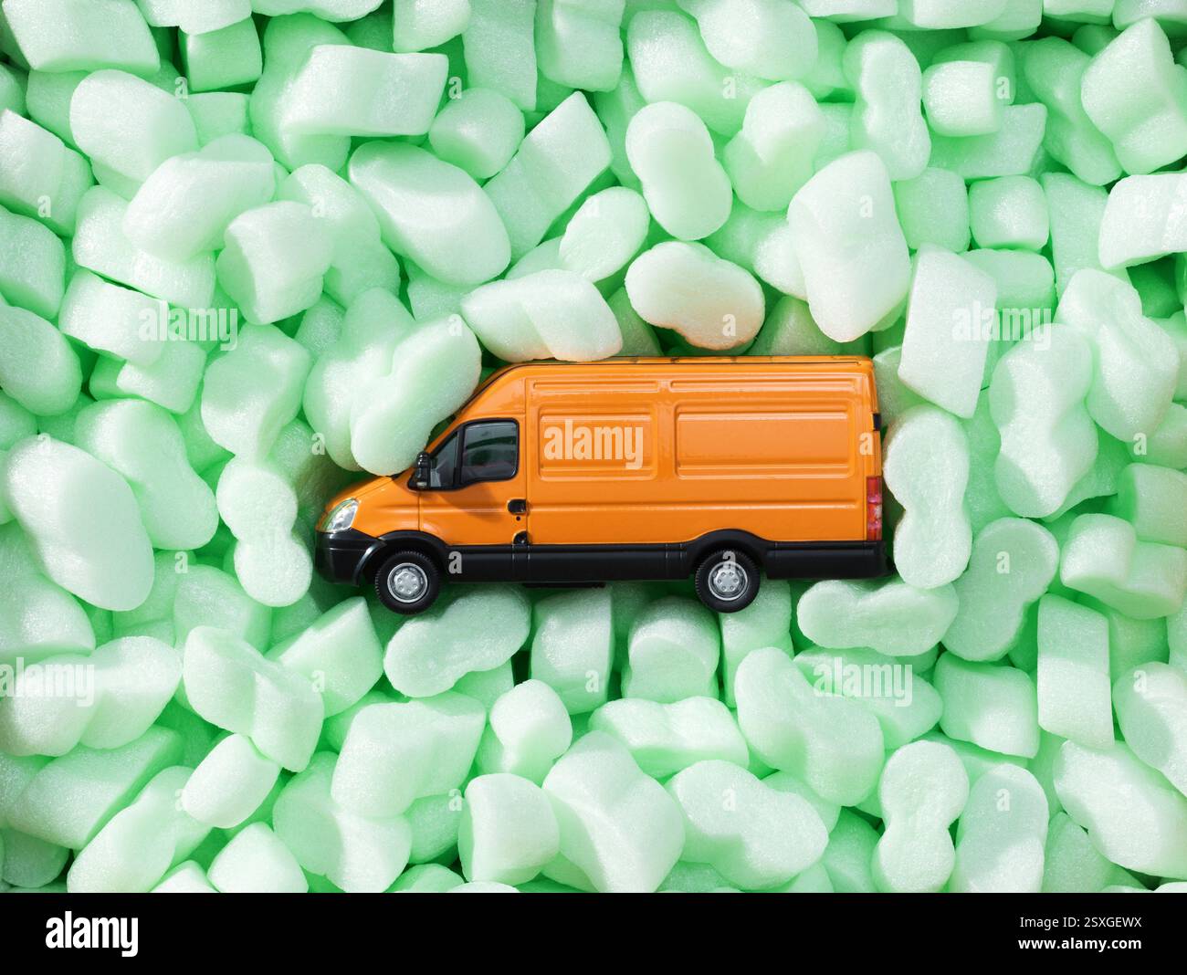 Cute small toy delivery van surrounded by loose fill packing chips ...