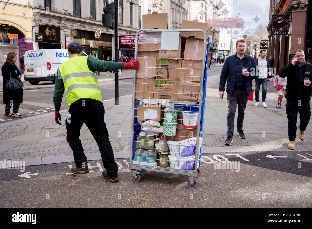 A man drags a cage full of food orders across the street in front of ...