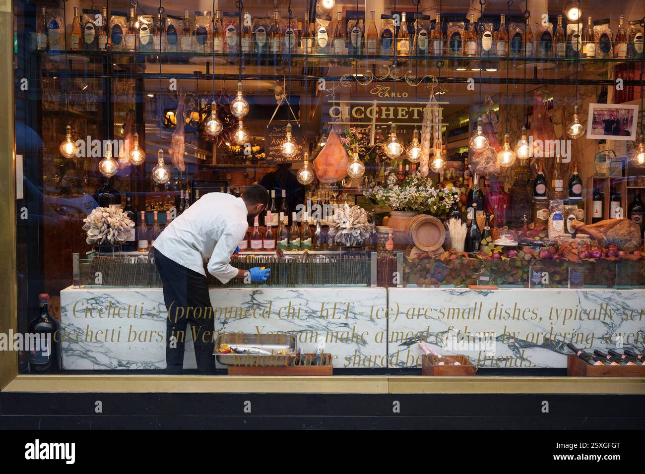 A member of staff at Cicchetti by San Carlo arranges a display of fish ...