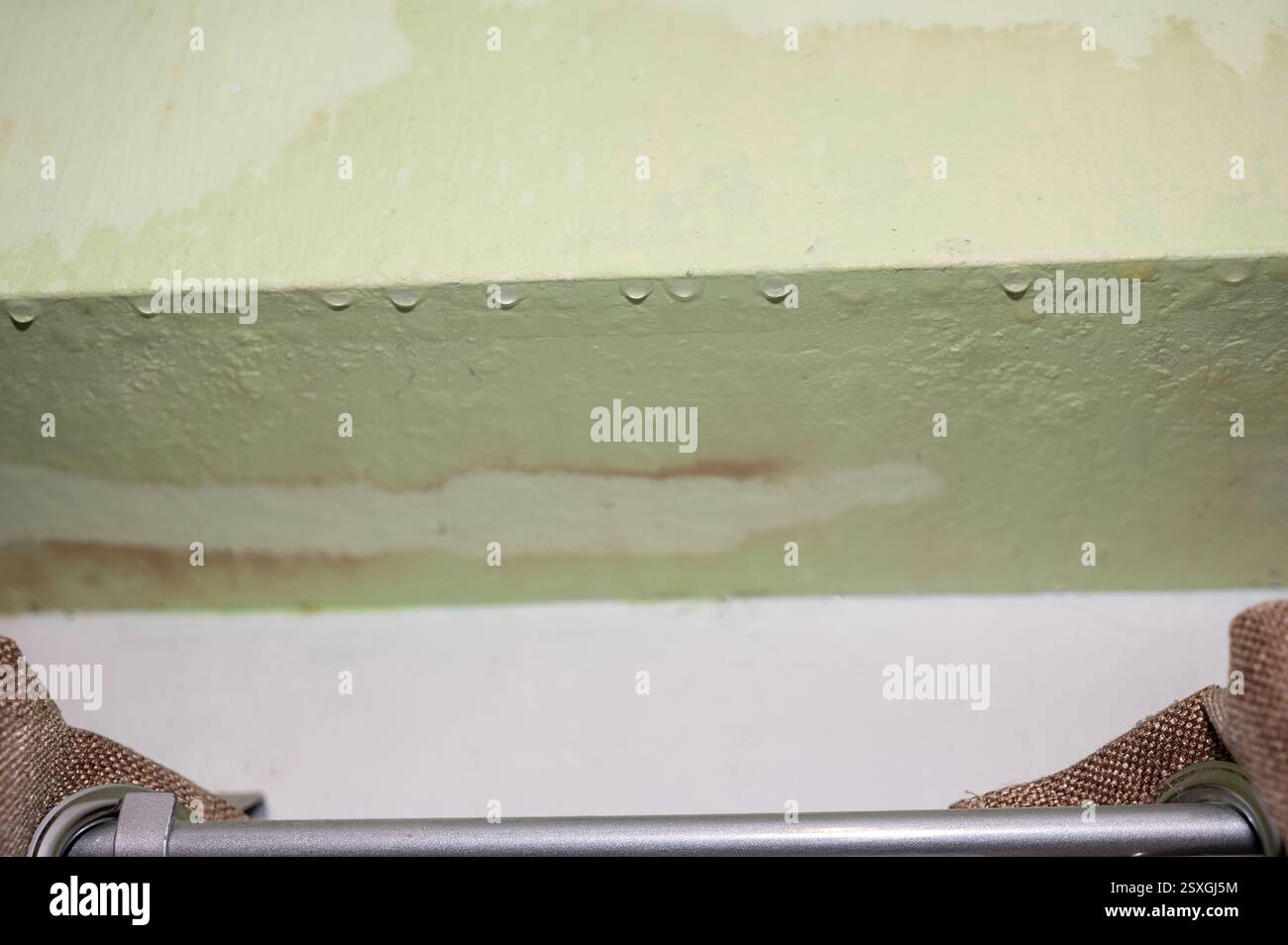 Wet wall in an apartment, with water drops and discolored wallpaper ...