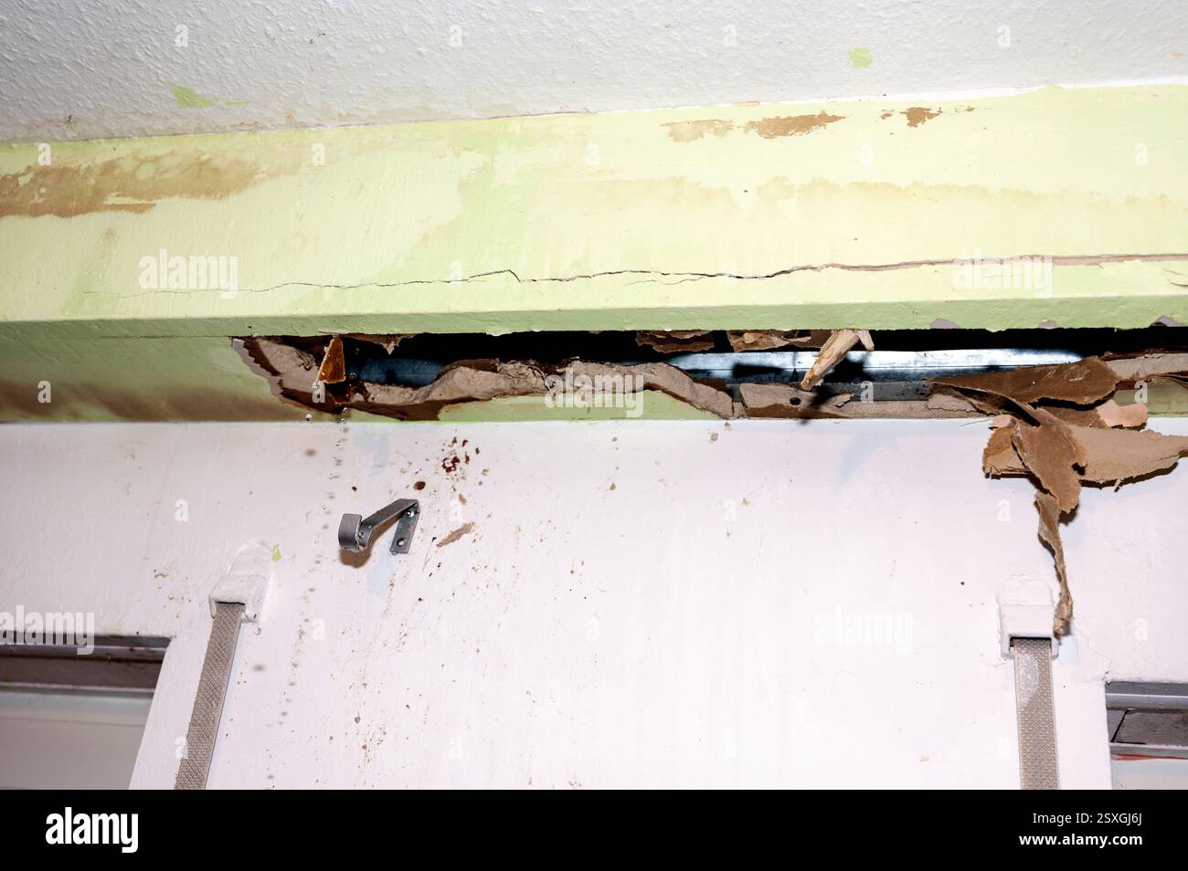 Wet and partially pried open ceiling wall in an apartment, with water ...