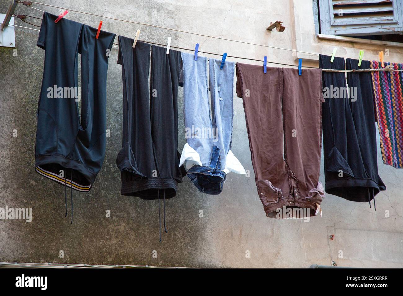 There are various clothes hanging on a clothes line outside a building ...