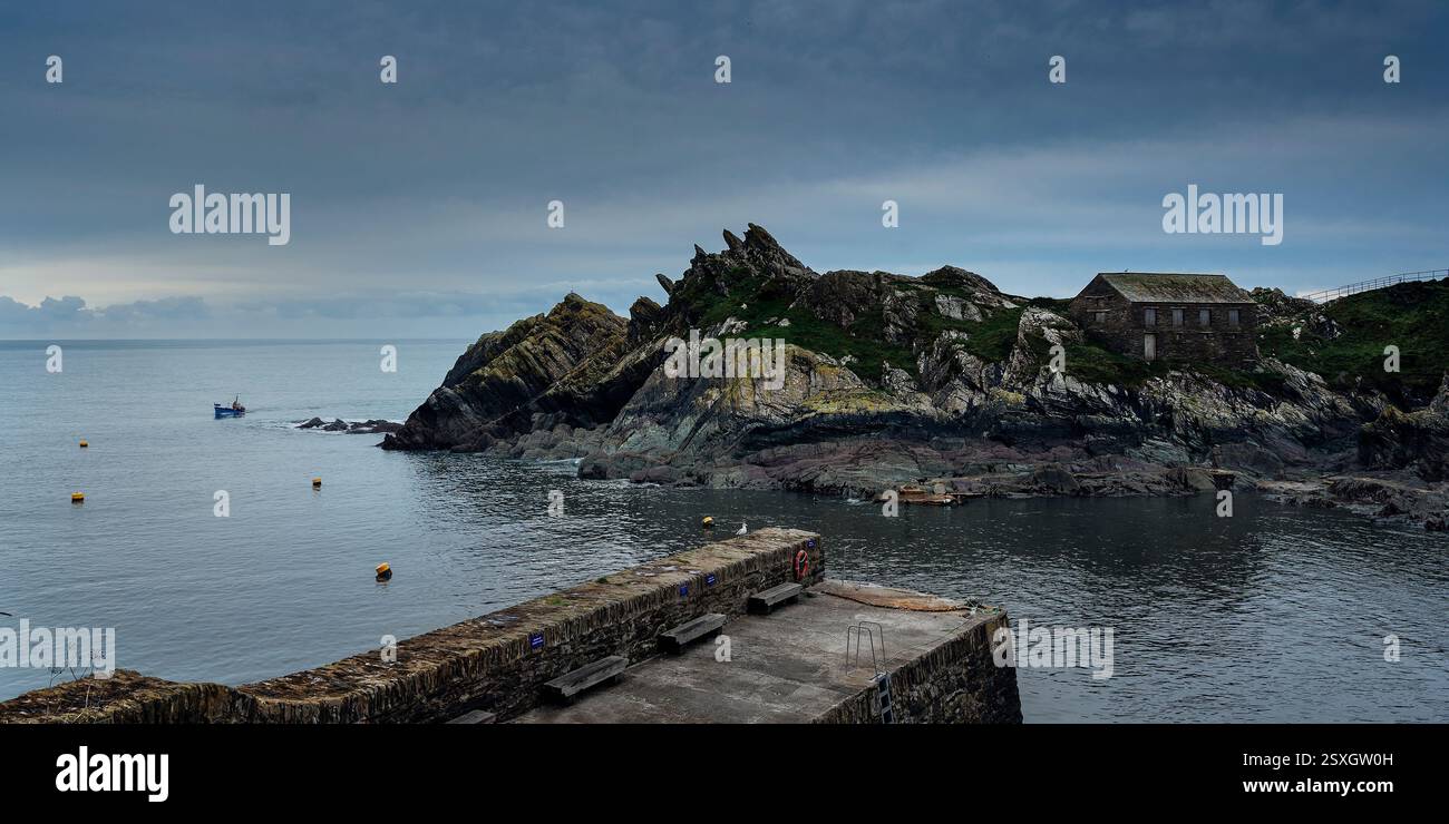Fishing boat entering Polperro Harbour, with Peak Rock & the Net Loft ...