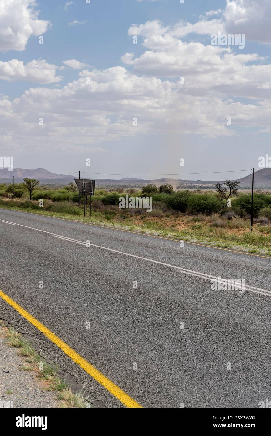 landscape with dust devil near B1 tar road in green desert countryside ...