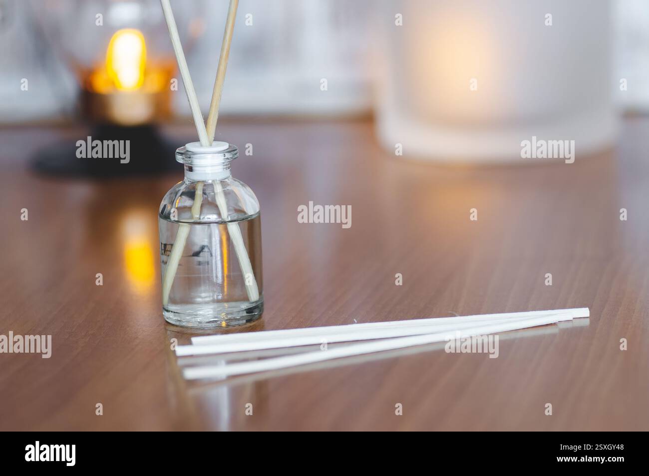 Decorating, hügge and aromatherapy concept - scented reed diffuser, burning candle Stock Photo ...