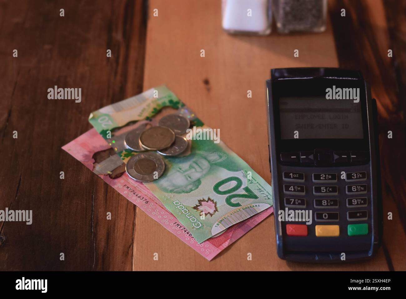 Canadian cash money and payment terminal on restaurant table Stock ...