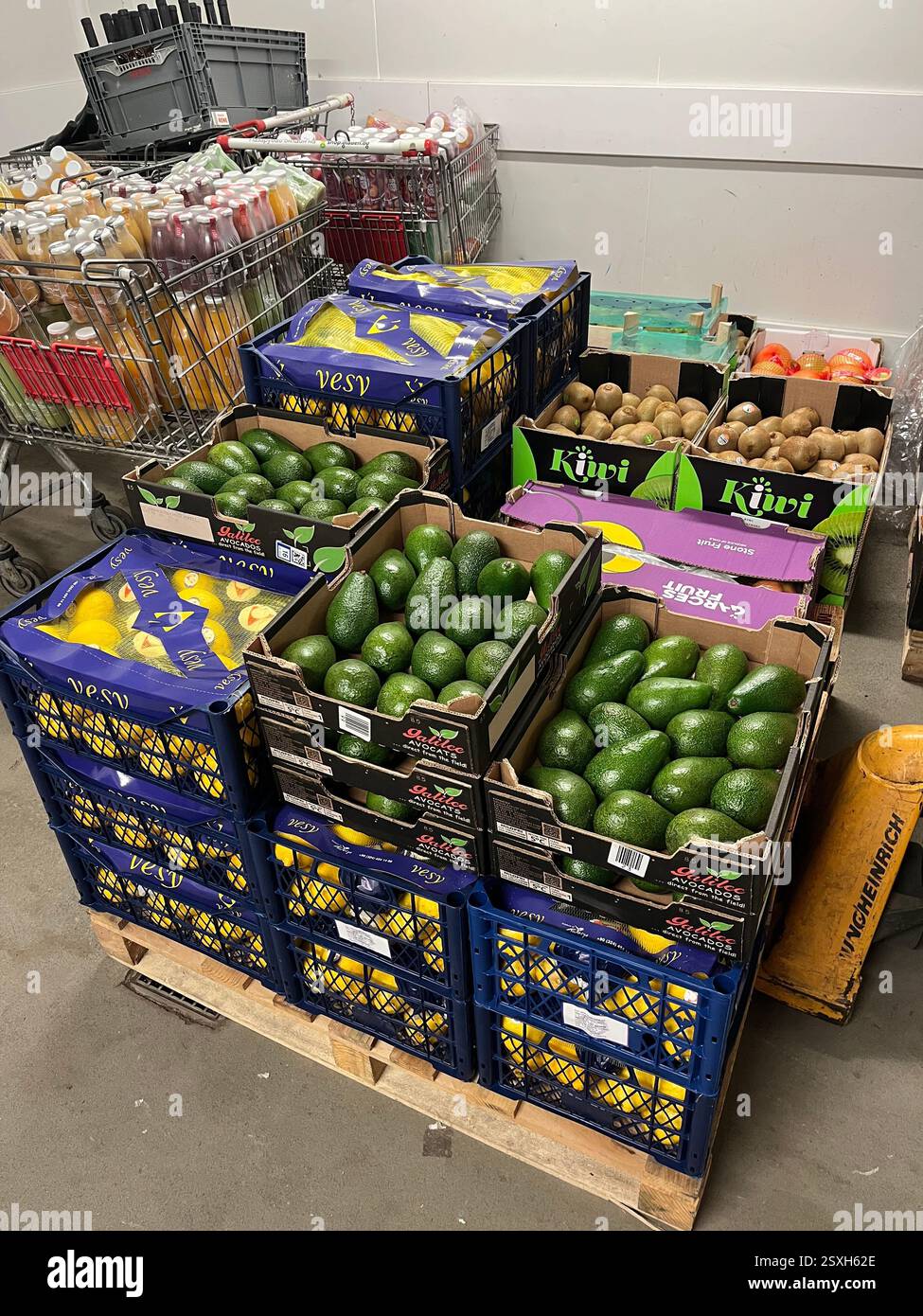 Stacked crates filled with assorted fruits and vegetables stored in a ...