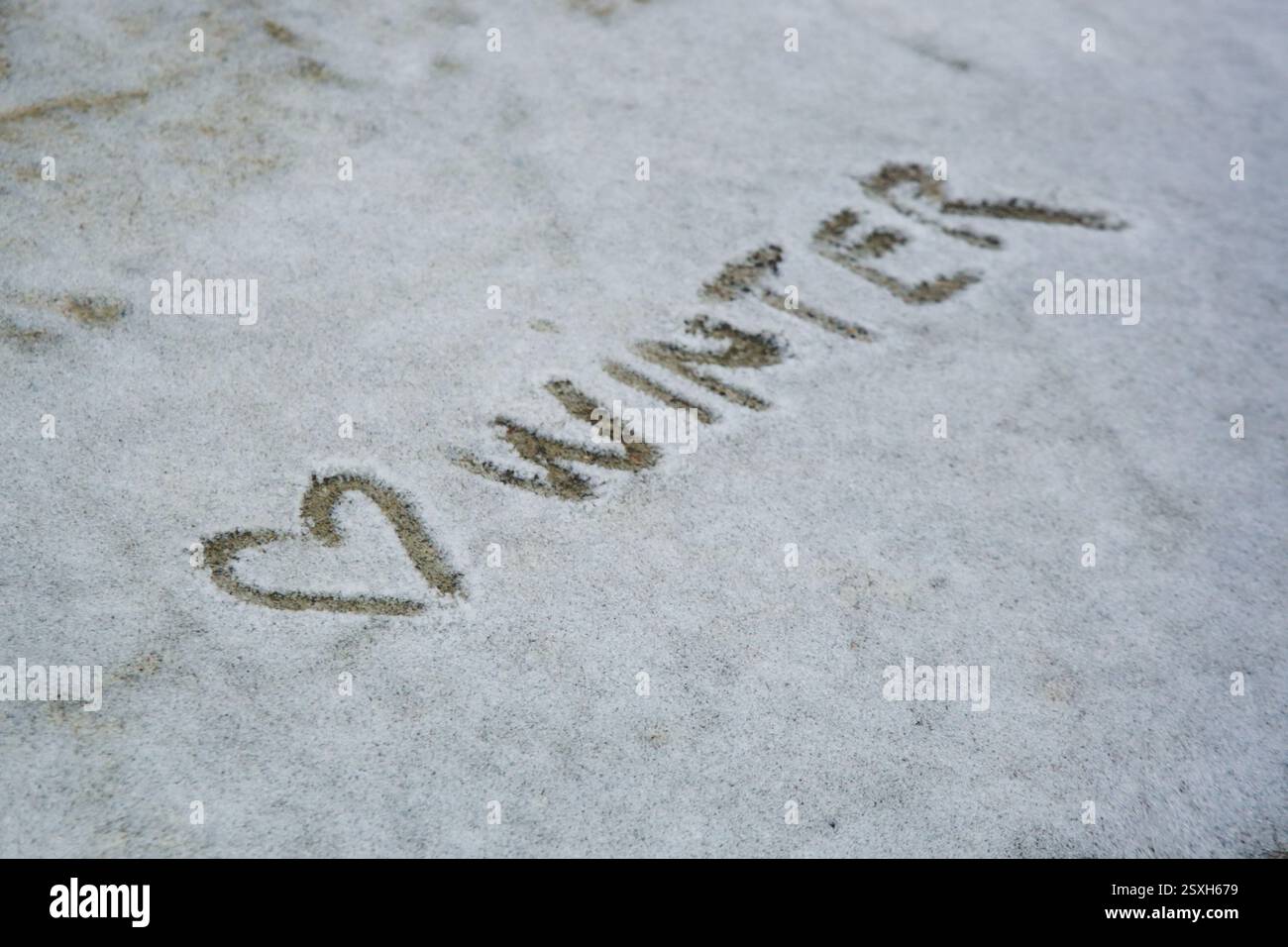 The word winter with heart next to it written in the snow Stock Photo ...