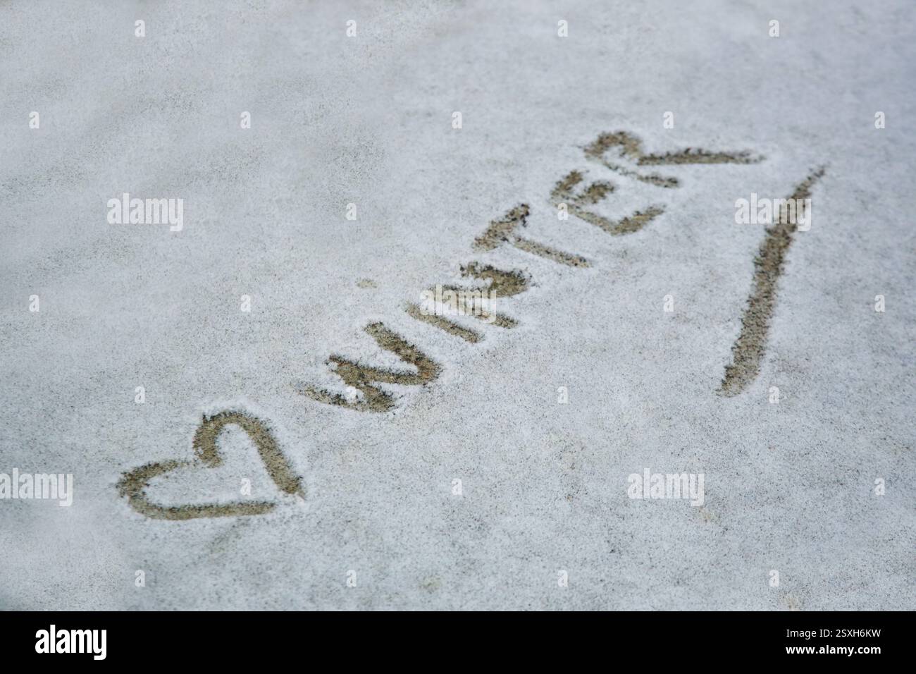 The word winter with heart next to it written in the snow Stock Photo ...