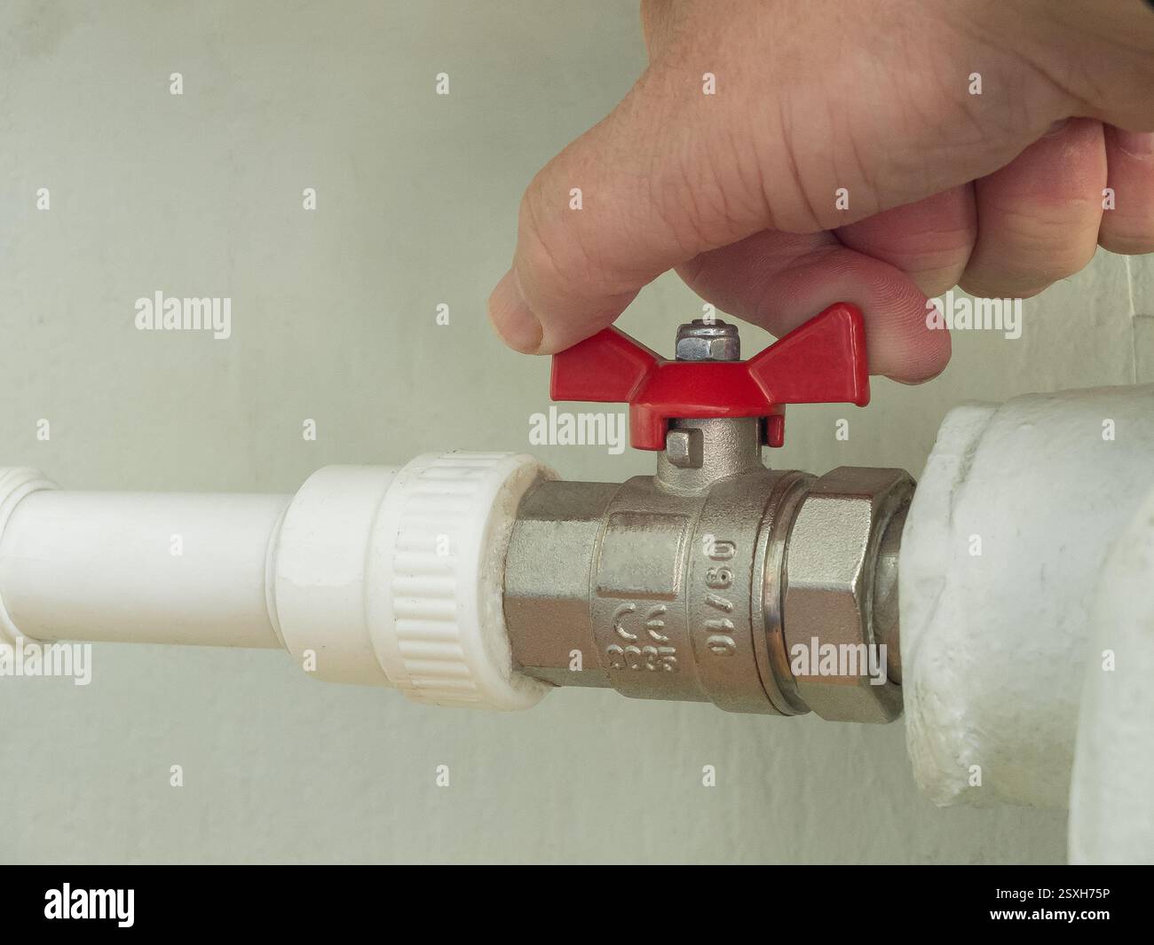 Male hand on the valves of the heating battery close-up Stock Photo - Alamy