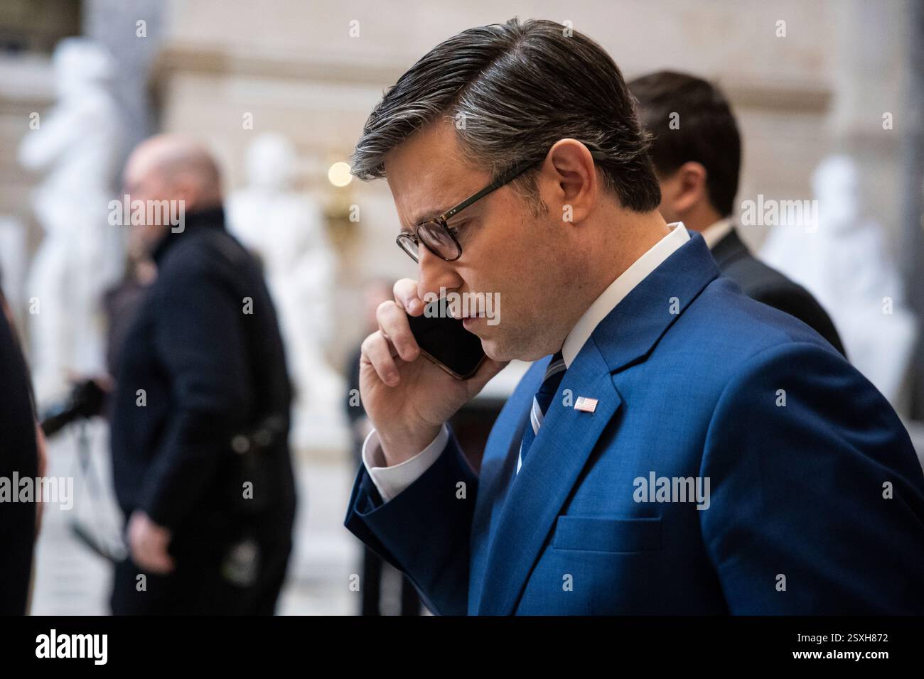 House Speaker Mike Johnson (R-La.) holds his phone to his ear as he ...