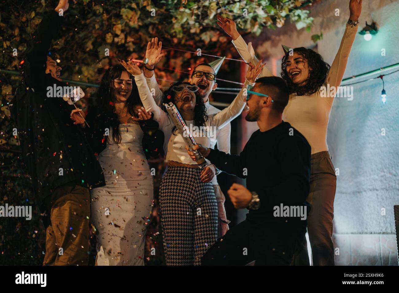 Group of friends celebrating a festive occasion with confetti and joy ...
