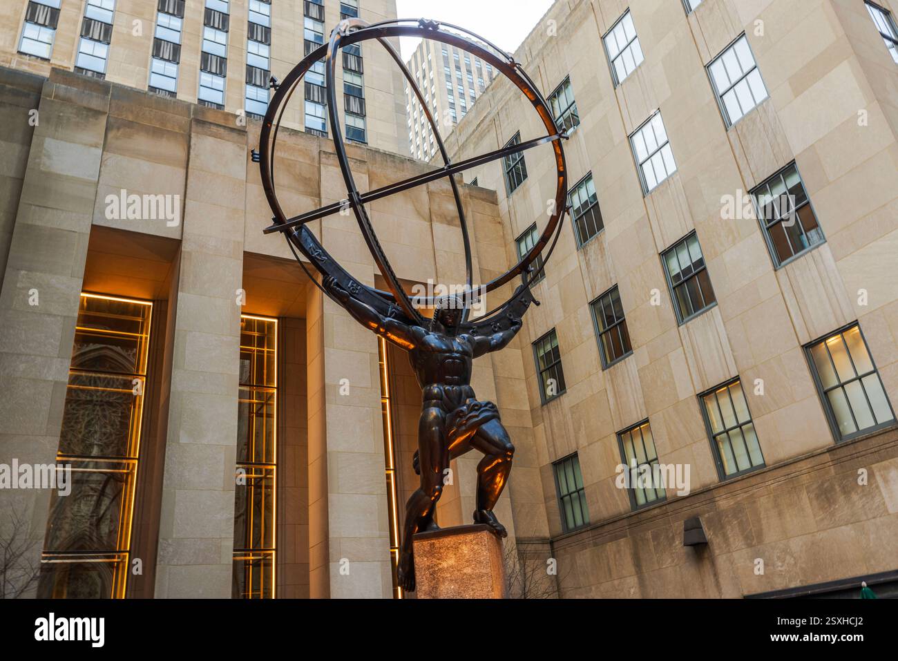 Bronze Atlas statue holding an armillary sphere in front of Art Deco ...