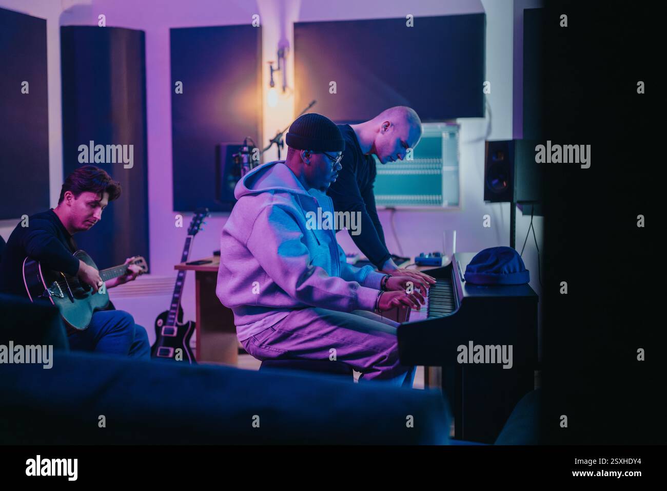 Multiracial musicians collaborating in a modern recording studio ...