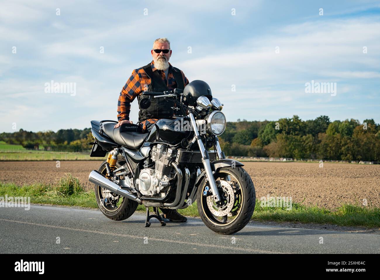 Motorräder - cooler Biker mit grauem Bart posiert mit seinem Yamaha ...