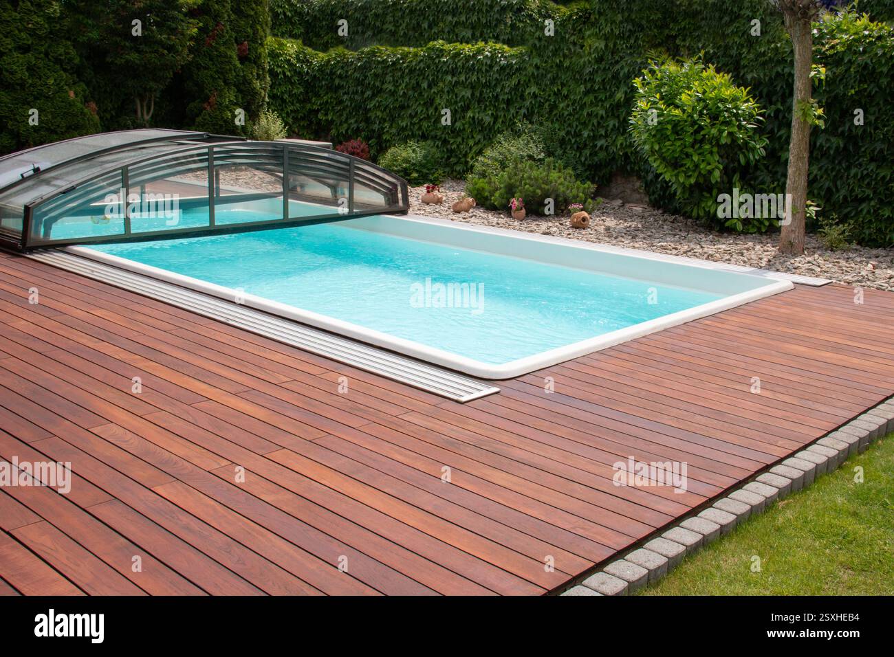 A beautiful backyard features a clear blue pool with a retractable ...