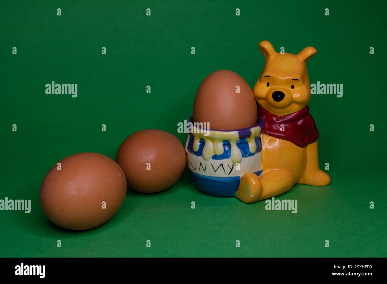 Winnie the pooh egg cup isolated on green background with copy space ...