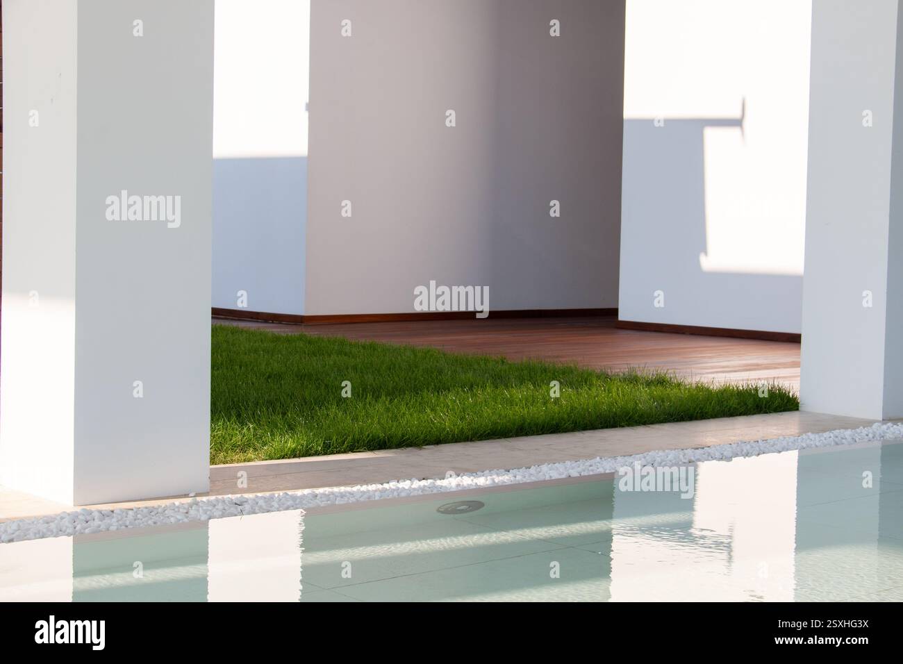 Modern house atrium with hardwood timber decking and pond. A peaceful ...