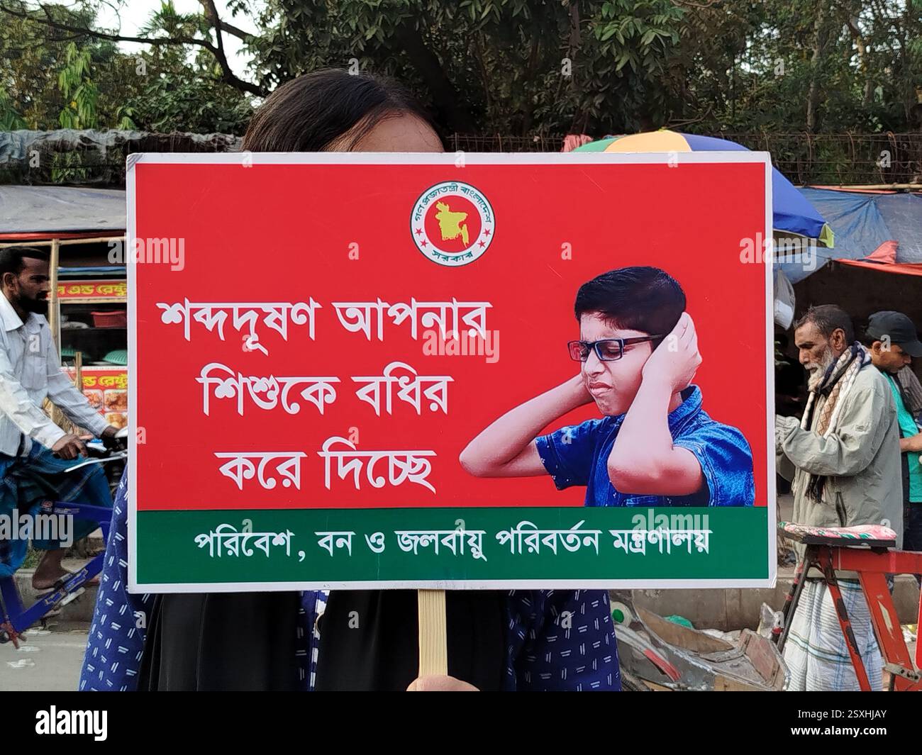 Dhaka, Bangladesh. 25th Feb, 2025. A volunteer holds a placard reading "Noise pollution is ...