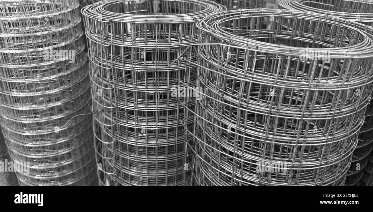 Metal wire coils are meticulously arranged in stacks within a well-lit ...
