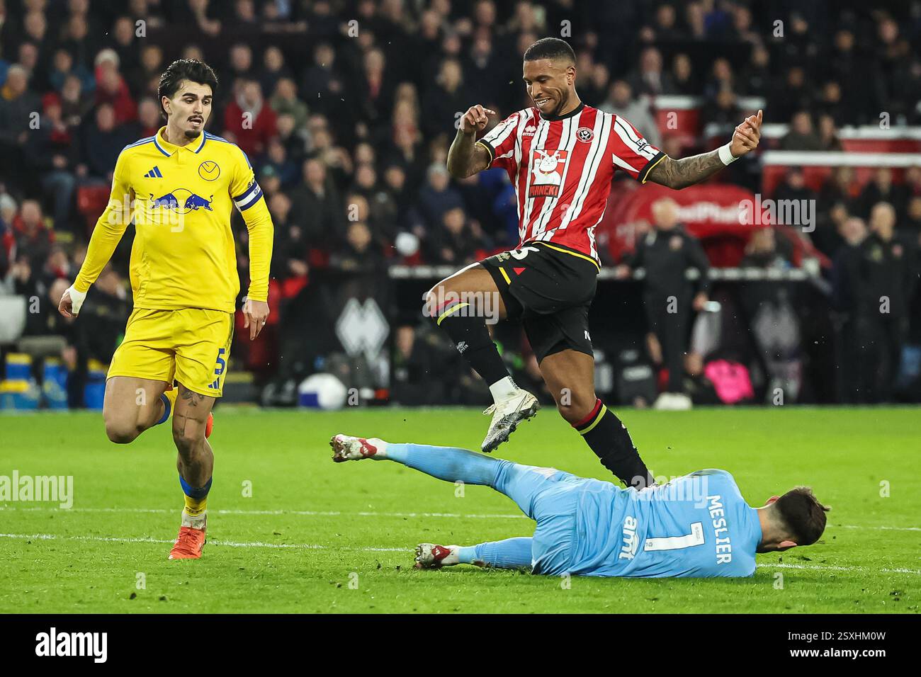 Illan Meslier of Leeds United makes a save at the feet of Tyrese ...